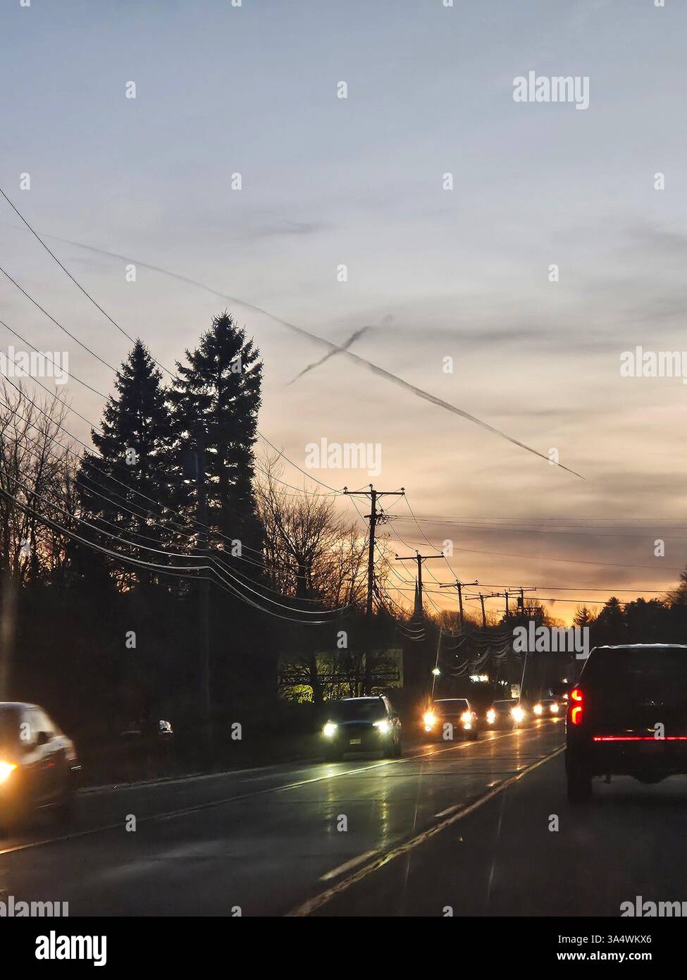 Cross in the sky of clouds or chemtrails at dusk on a dreary chilly ...