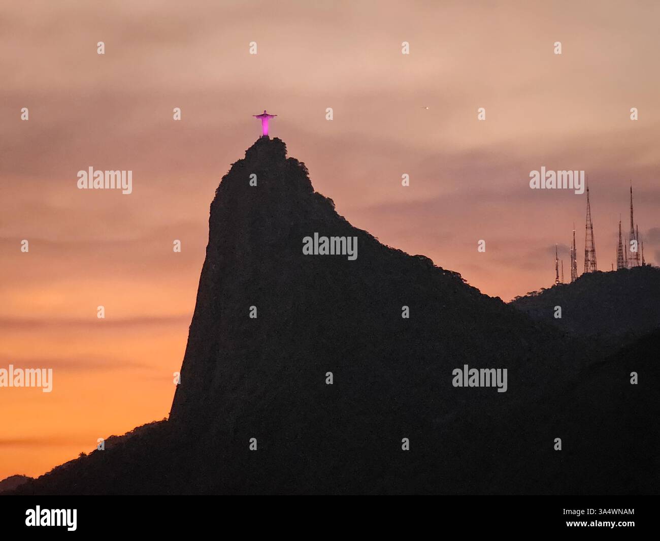 Iconic Christ the Redeemer Statue Lit in Pink Against a Vibrant Sunset ...
