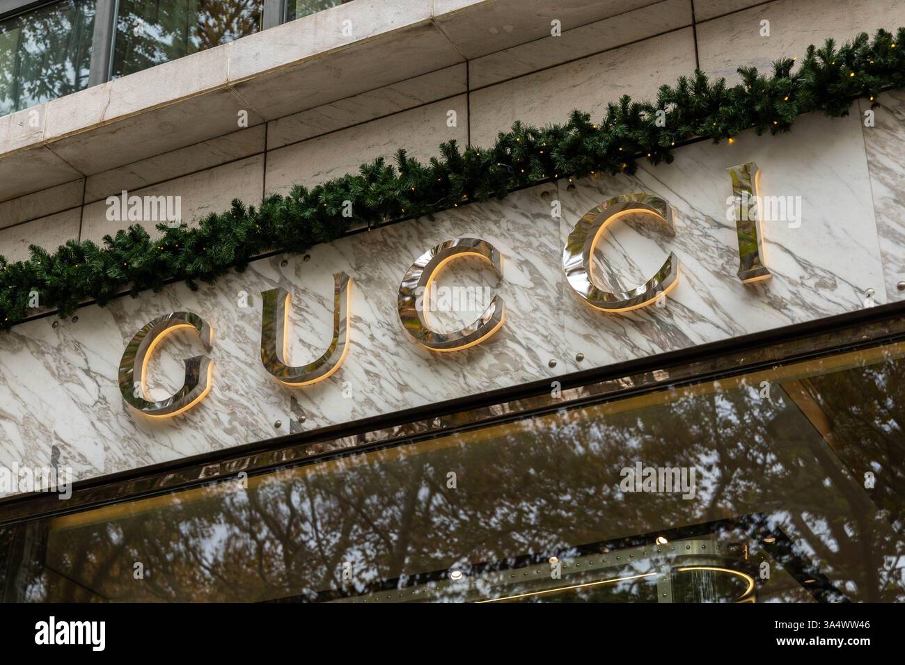 Shinny gold Gucci letters logo above the shop window on marble ...