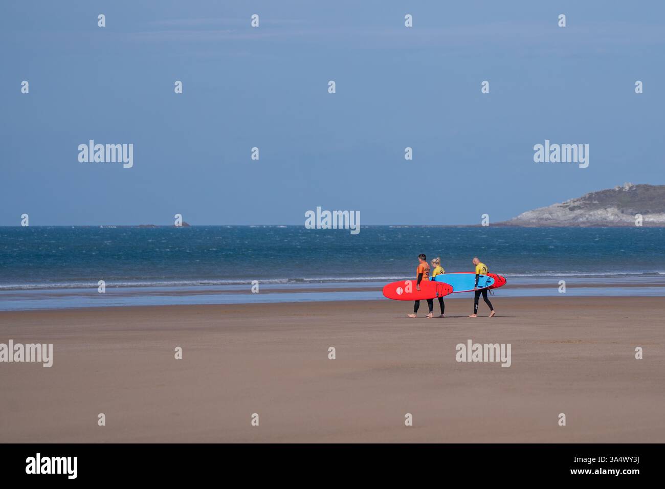 Surfers with their brightly coloured surf boards about to enter the ...
