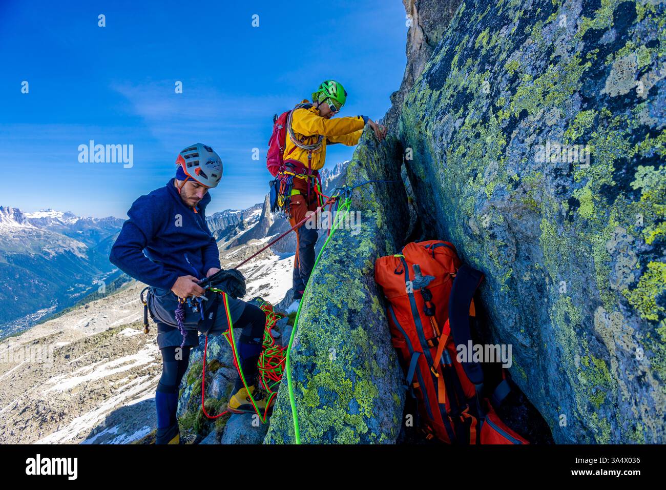 Alpinists climbing granite mountain walls in the Alps. Difficult alpine ...