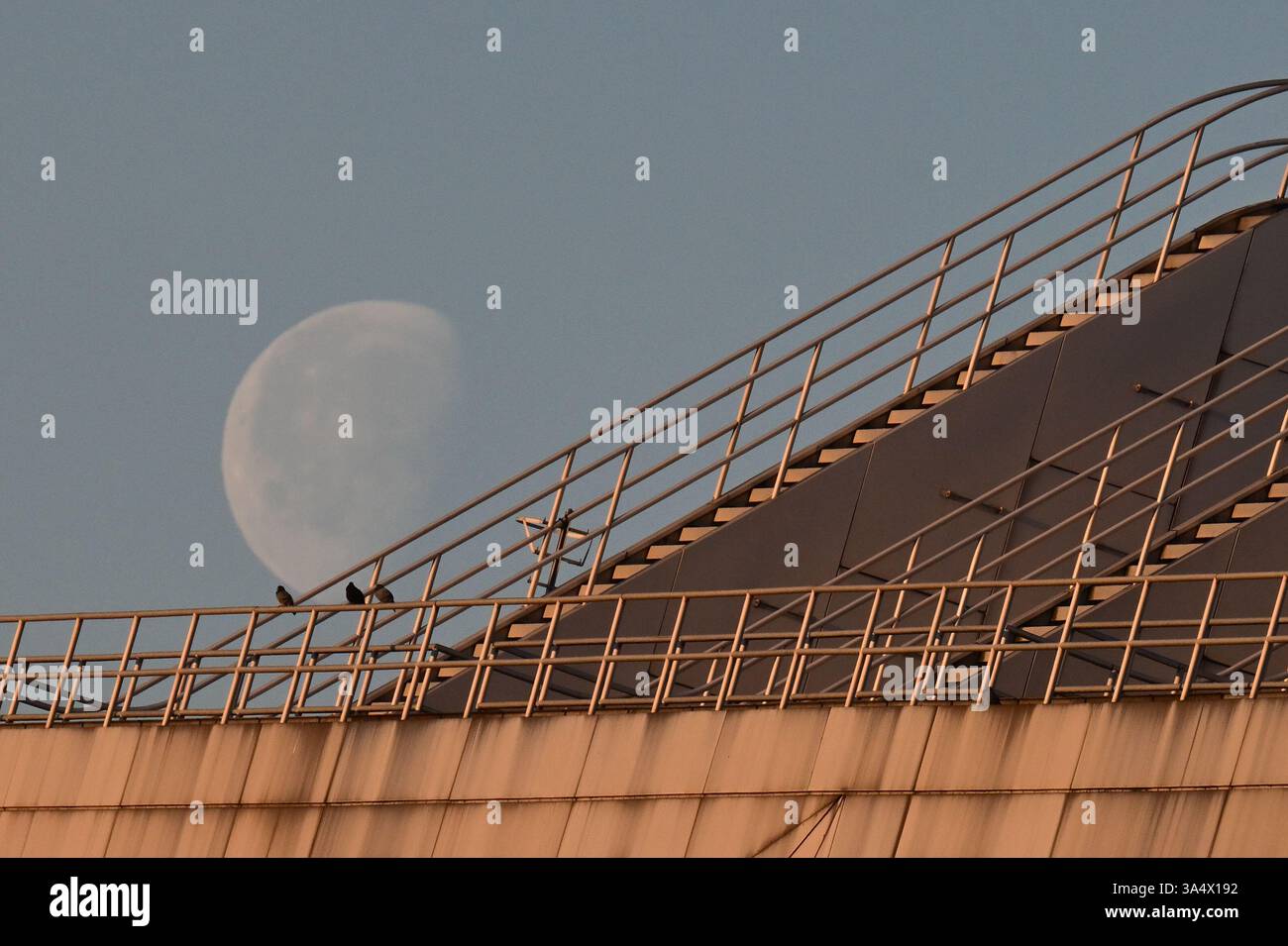 Berlin, Germany. 20th Mar, 2025. The moon sets behind the ICC. Credit: Sebastian Gollnow/dpa ...
