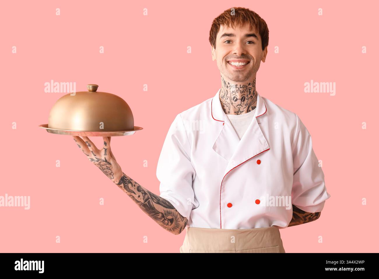 Tattooed happy male chef with tray and cloche on pink background Stock ...
