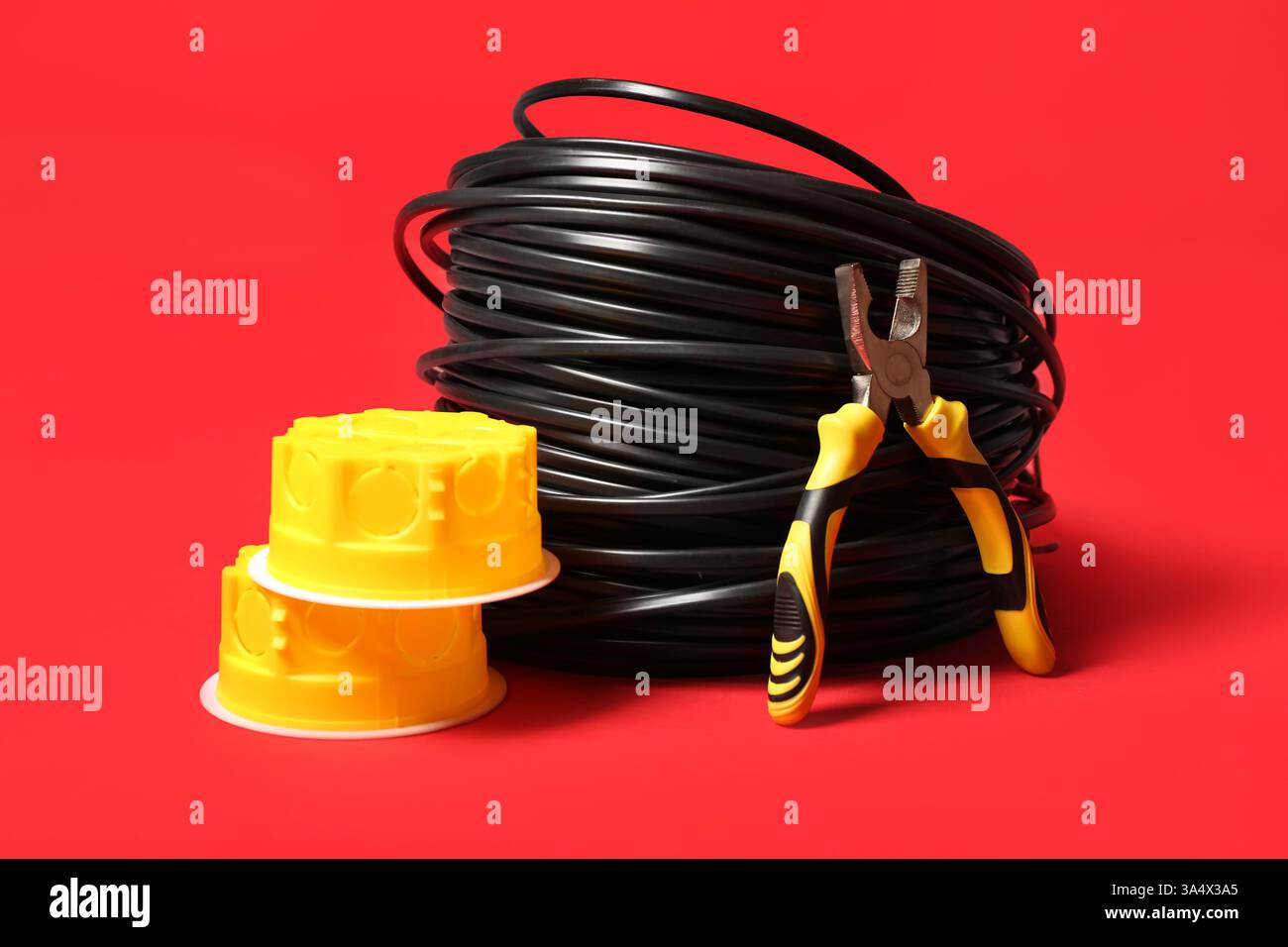 Electrical junction boxes, pliers and cables on red background Stock ...