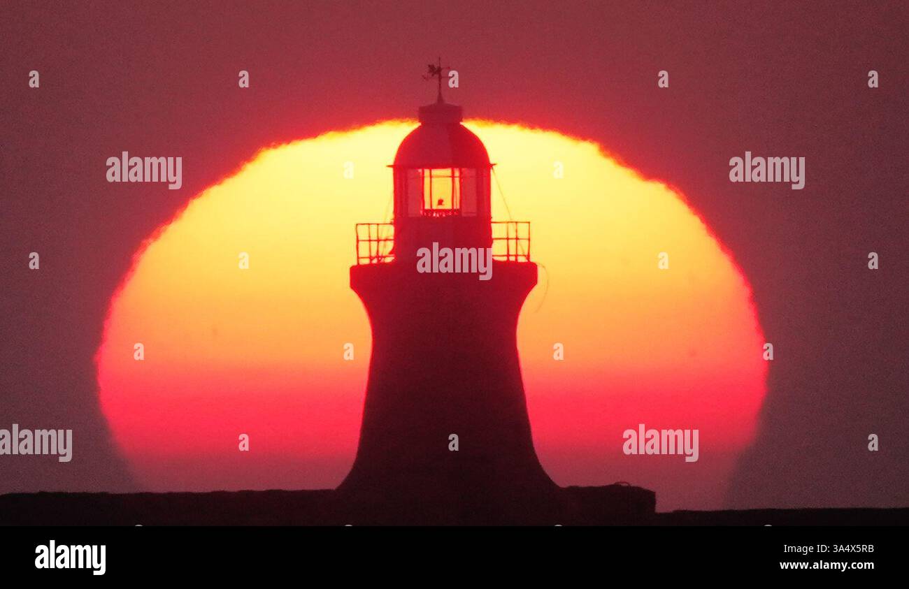 The sun rises over South Shields lighthouse at the mouth of the Tyne on ...