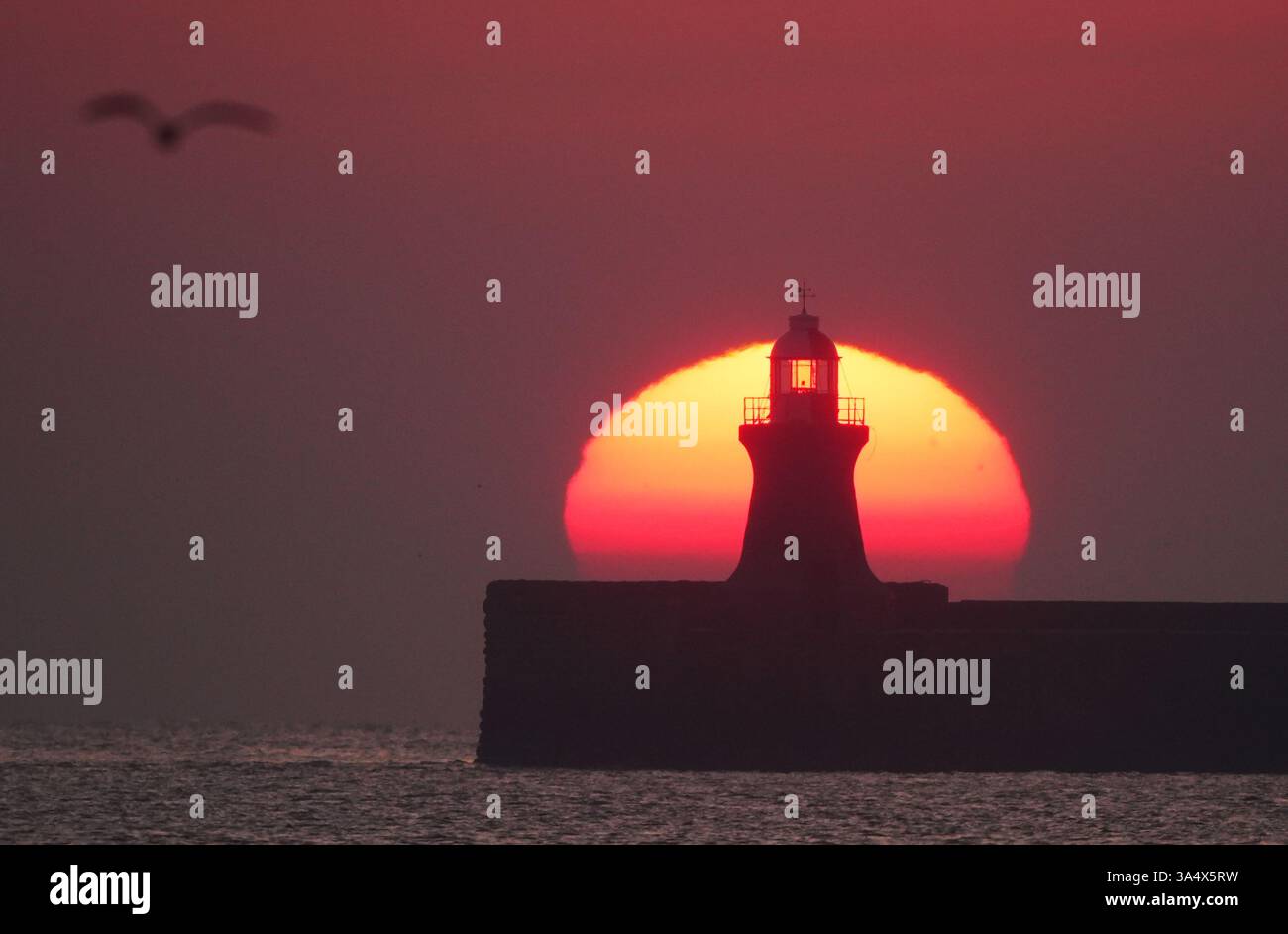 The sun rises over South Shields lighthouse at the mouth of the Tyne on ...