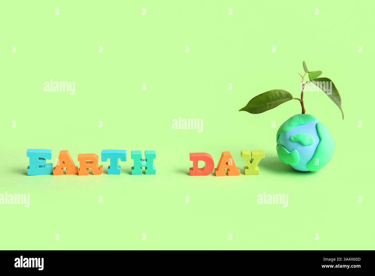 Planet Earth with plant and words EARTH DAY on green background. World ...