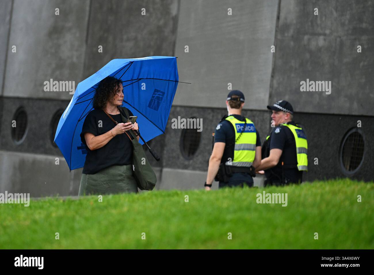 A spectator with an umbrella arrives to the stadium for the AFL Round 2 ...