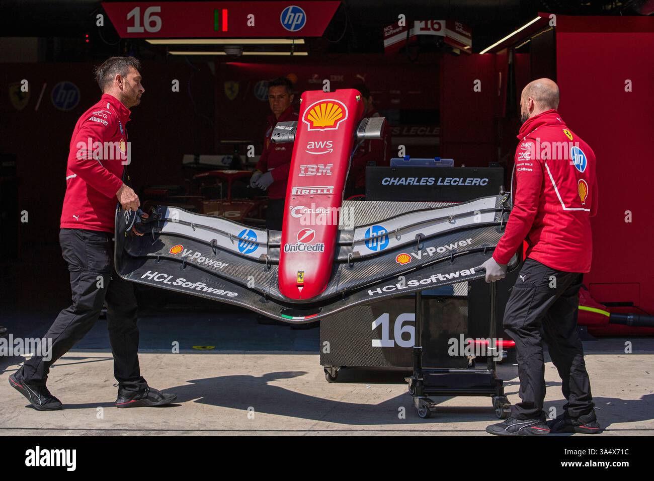 Ferrari crew members work on the car of the team's driver Charles ...