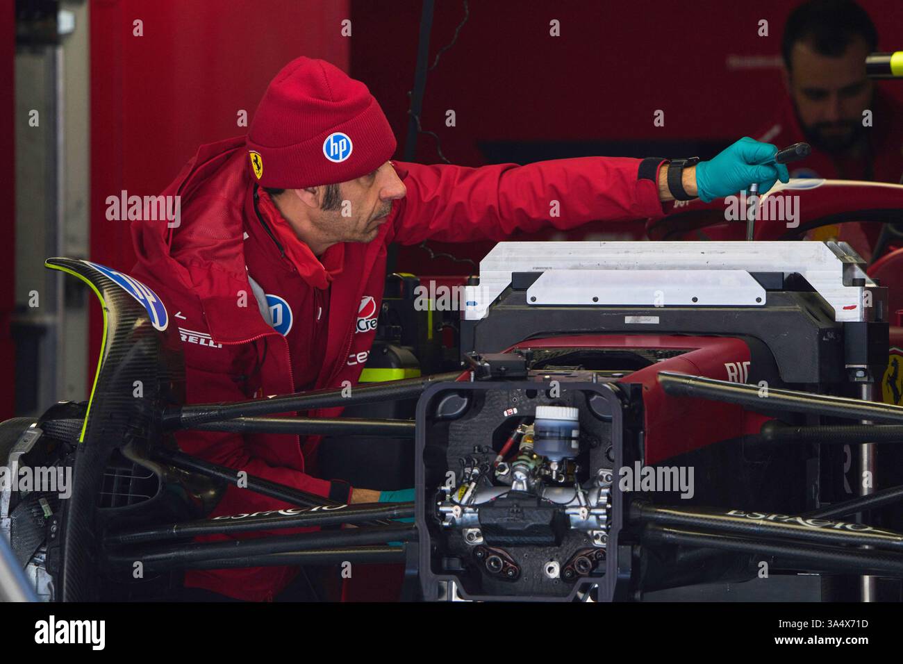 A Ferrari crew member works on the car of the team's driver Lewis ...