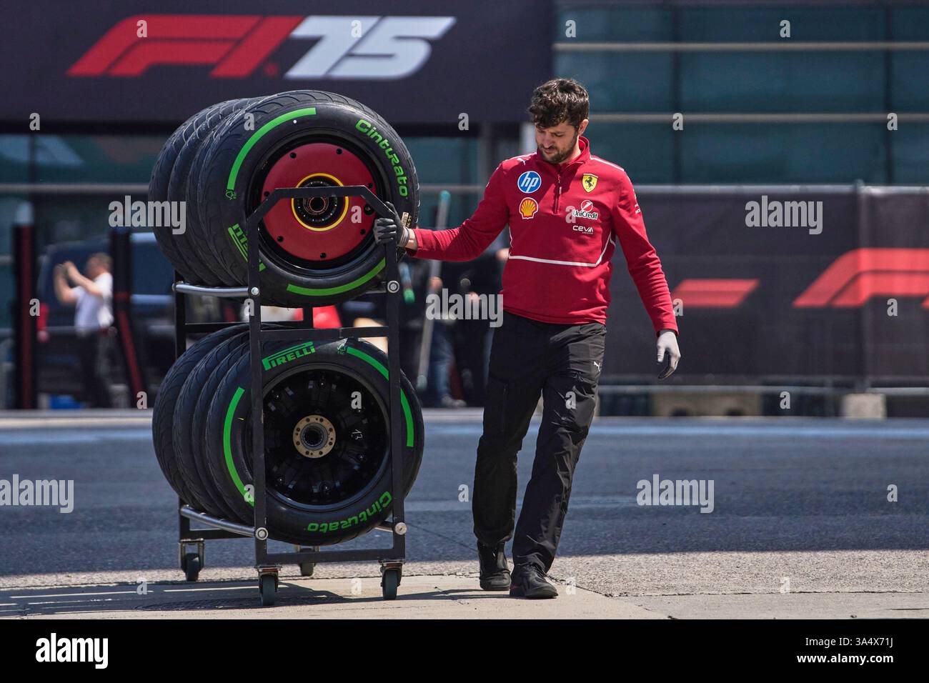 A Ferrari crew member transfers the tyre to the team garage ahead of ...