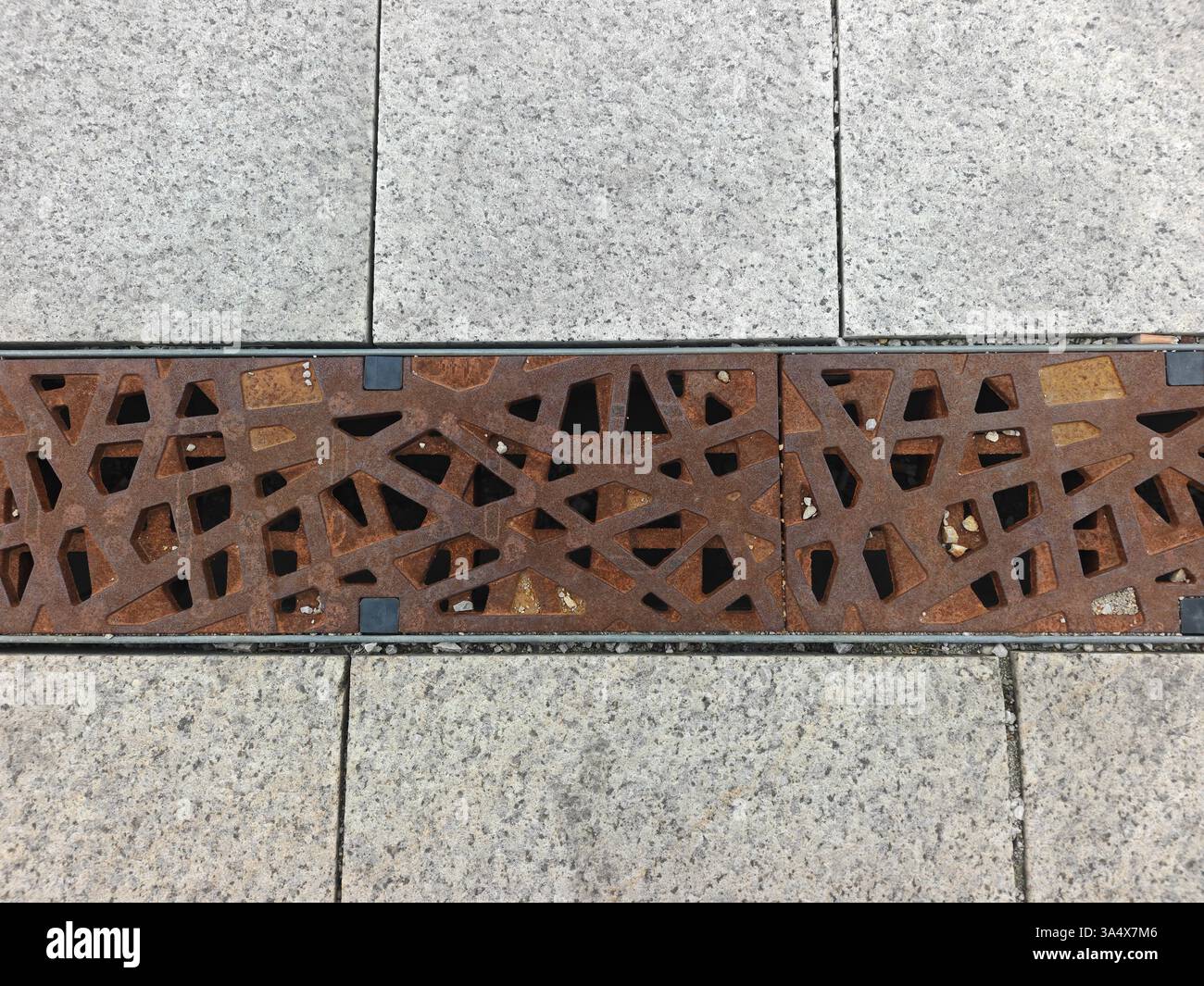 Metal sewage gutter grid on a sidewalk Stock Photo - Alamy