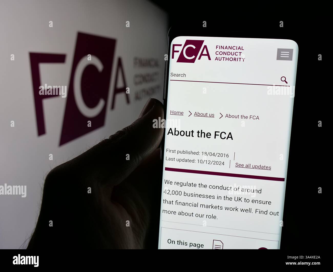 In this photo illustration, a person is holding a cellphone with the webpage of British ...