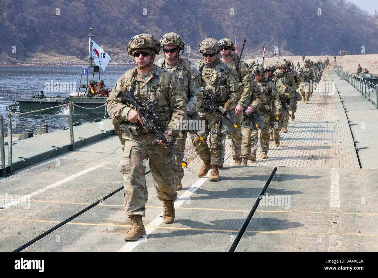 U.S. Army soldiers cross a floating bridge on the Imjin River during a ...