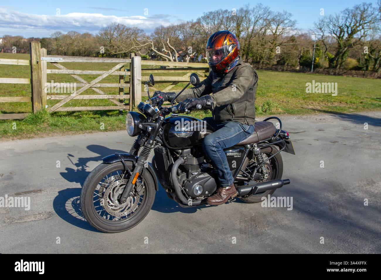 Triumph Bonneville T120 black; male Motorbike rider; two wheeled ...