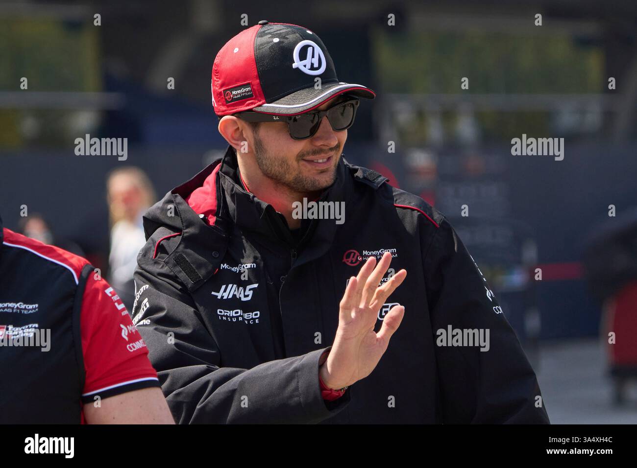 Haas driver Esteban Ocon of France waves as he arrives at the Shanghai ...