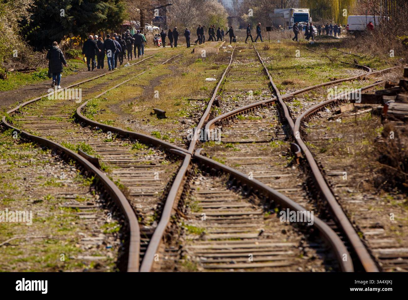 People walk along railway tracks, heading for the funeral ceremony of ...