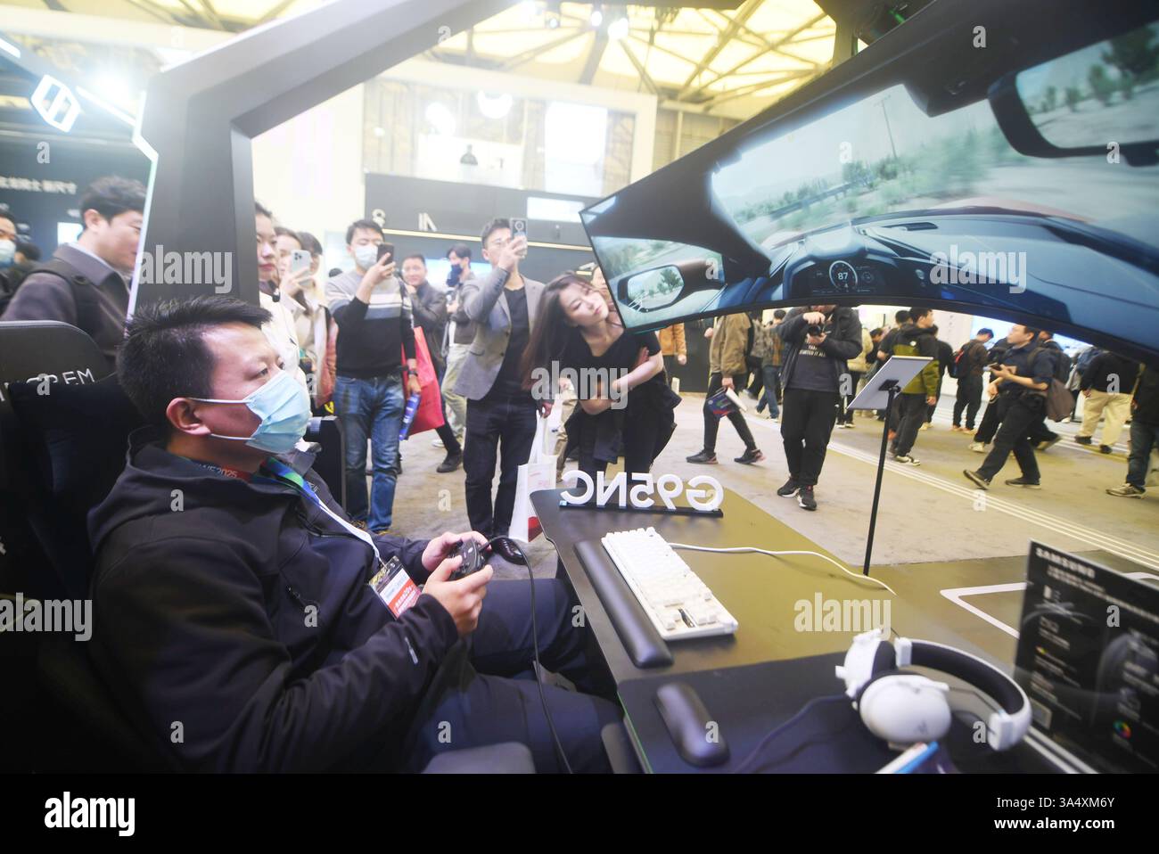 Visitors experience a racing car with a curved screen at the Samsung ...