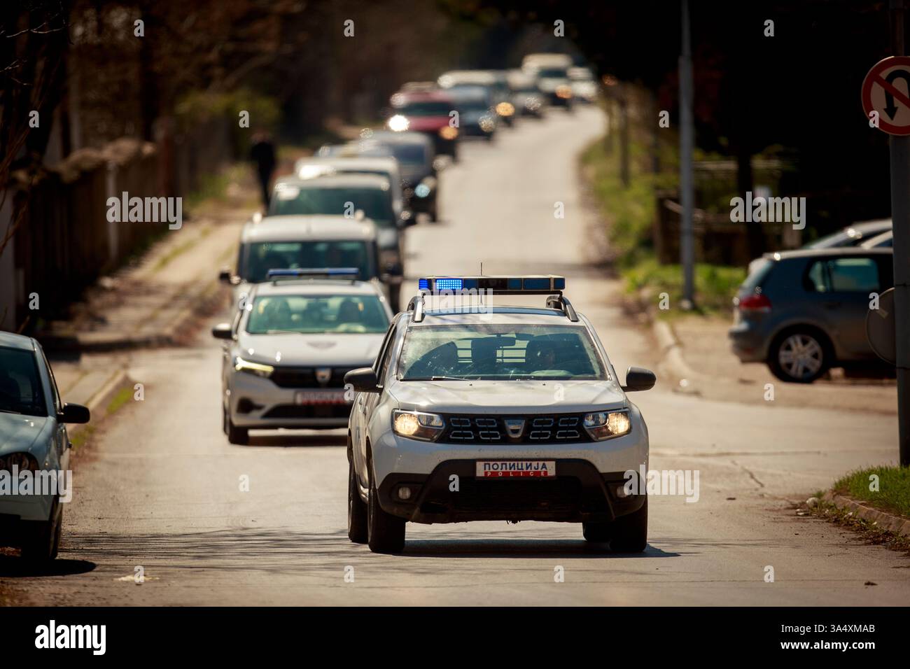 A police car leads a convoy of vehicles transporting the bodies of the ...