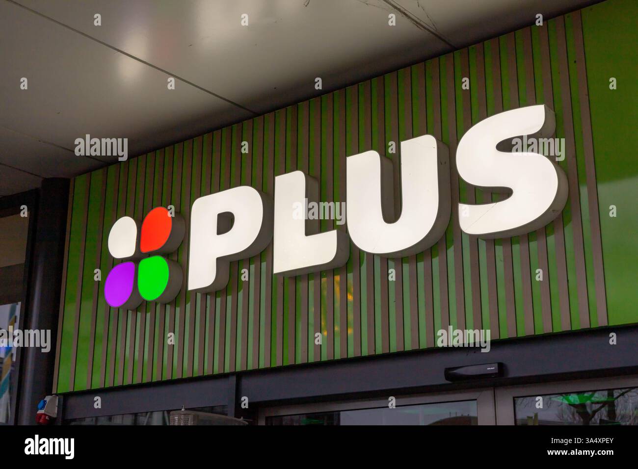 Plus logo sign. Plus is a supermarket groceries store with bikes parked ...