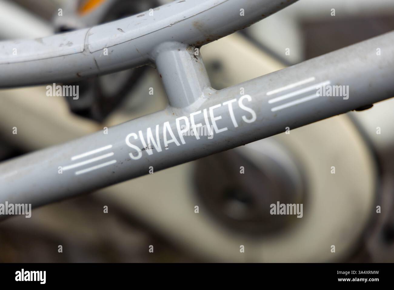 Detail of the Swapfiets logo on an orange bike parked in the city ...