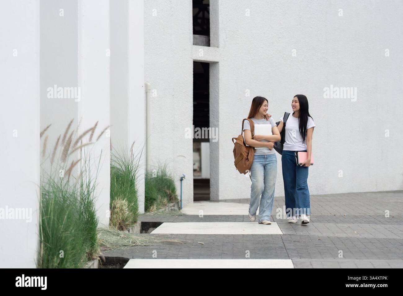Campus Life and Student Engagement. Two students happily walk through a ...