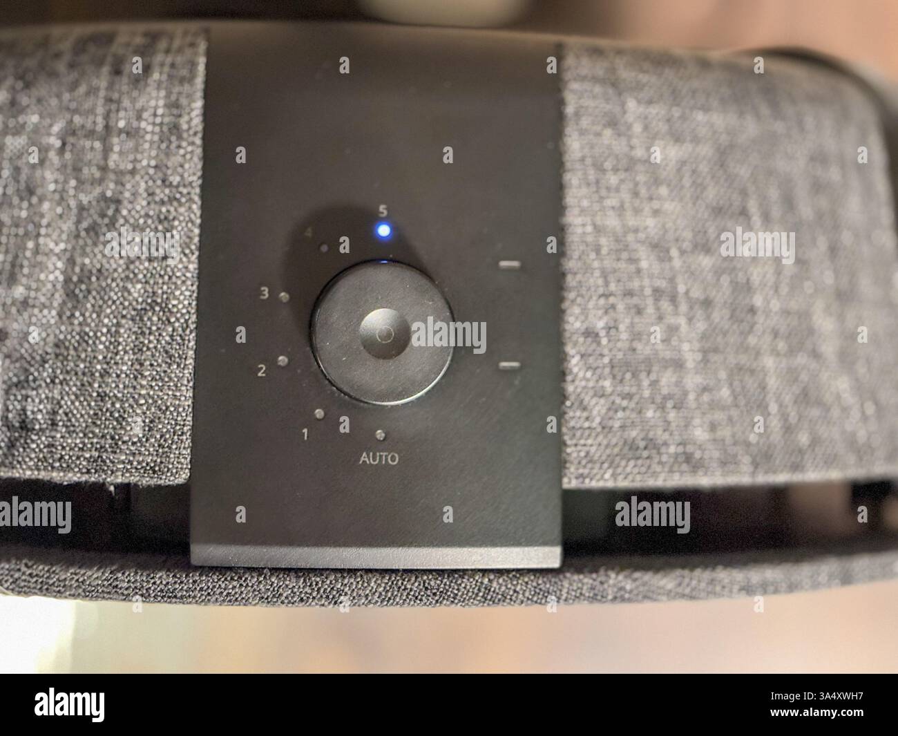 Close-up of a round power button of gray air purifier featuring ...