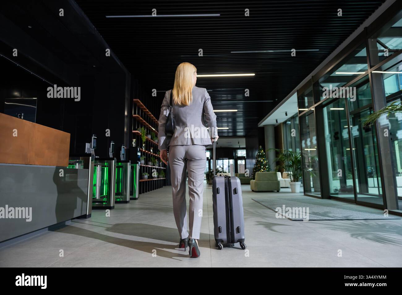 Woman in elegant suit going to the airport exit after arrival Stock Photo - Alamy