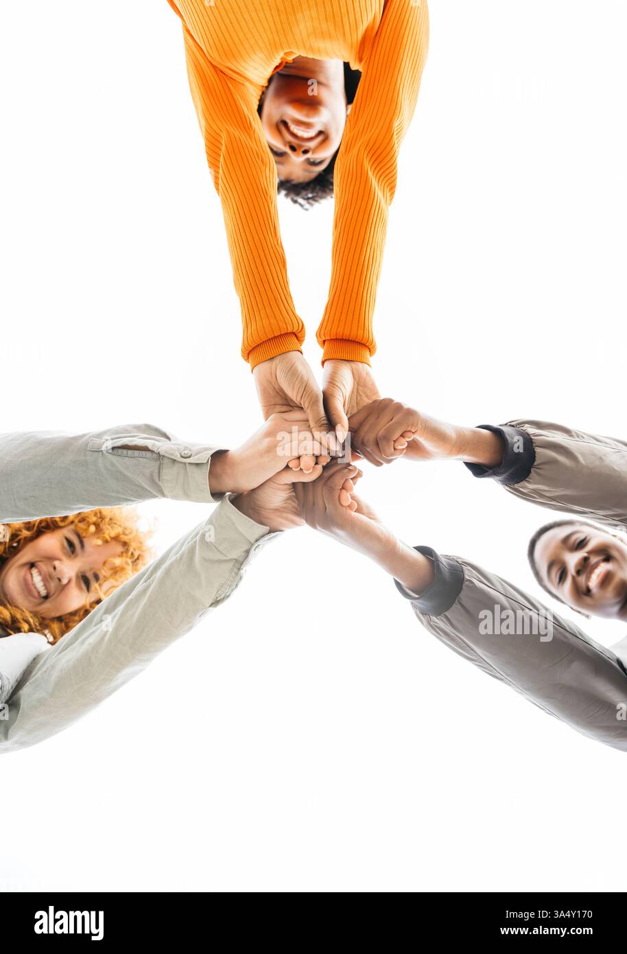 Three young people joining hands in a circle, symbolizing teamwork and ...