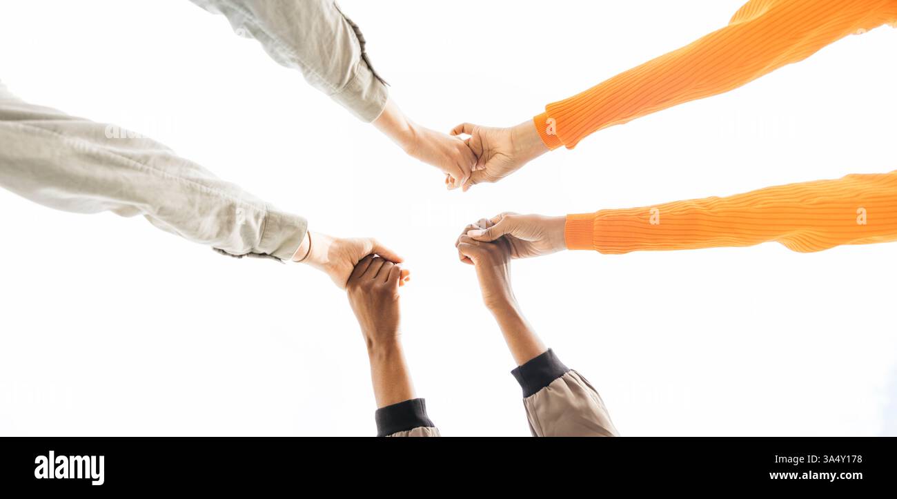 Three young people joining hands, creating a powerful symbol of unity ...