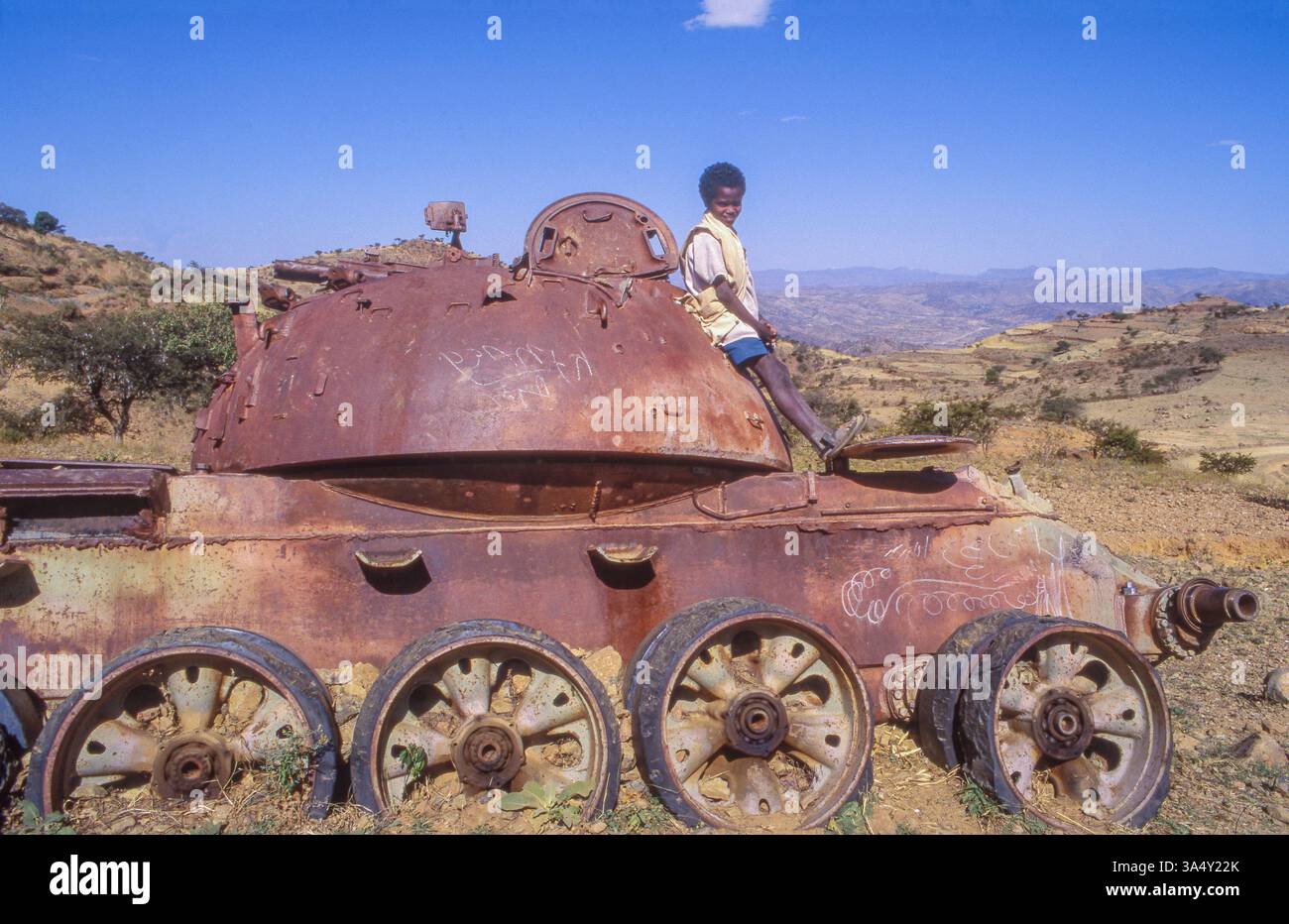 Ethiopia, Tigray; boy plays on an abandoned armored vehicle in the ...