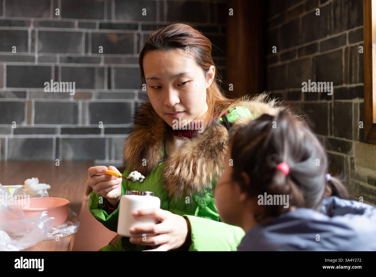 Beautiful Chinese woman splitting some food with her multiracial ...