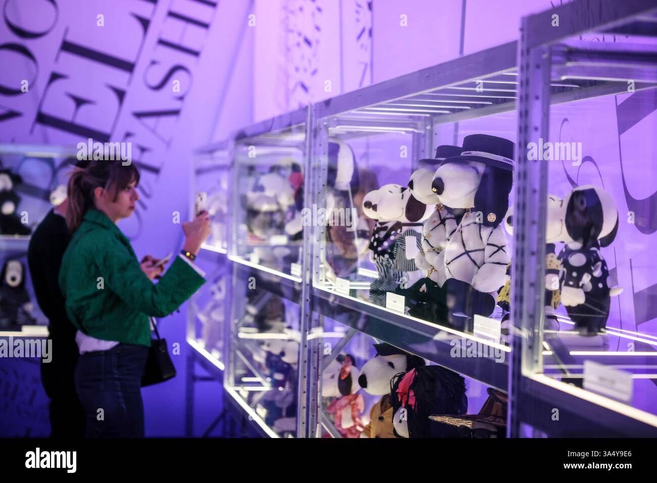 People watch figurines representing Snoopy wear creations as part of Peanuts' 75th Anniversary ...