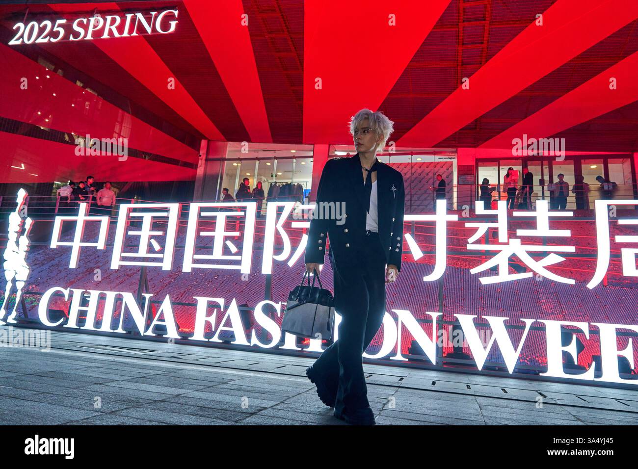 An attendee arrives for the opening show for China Fashion Week held in ...