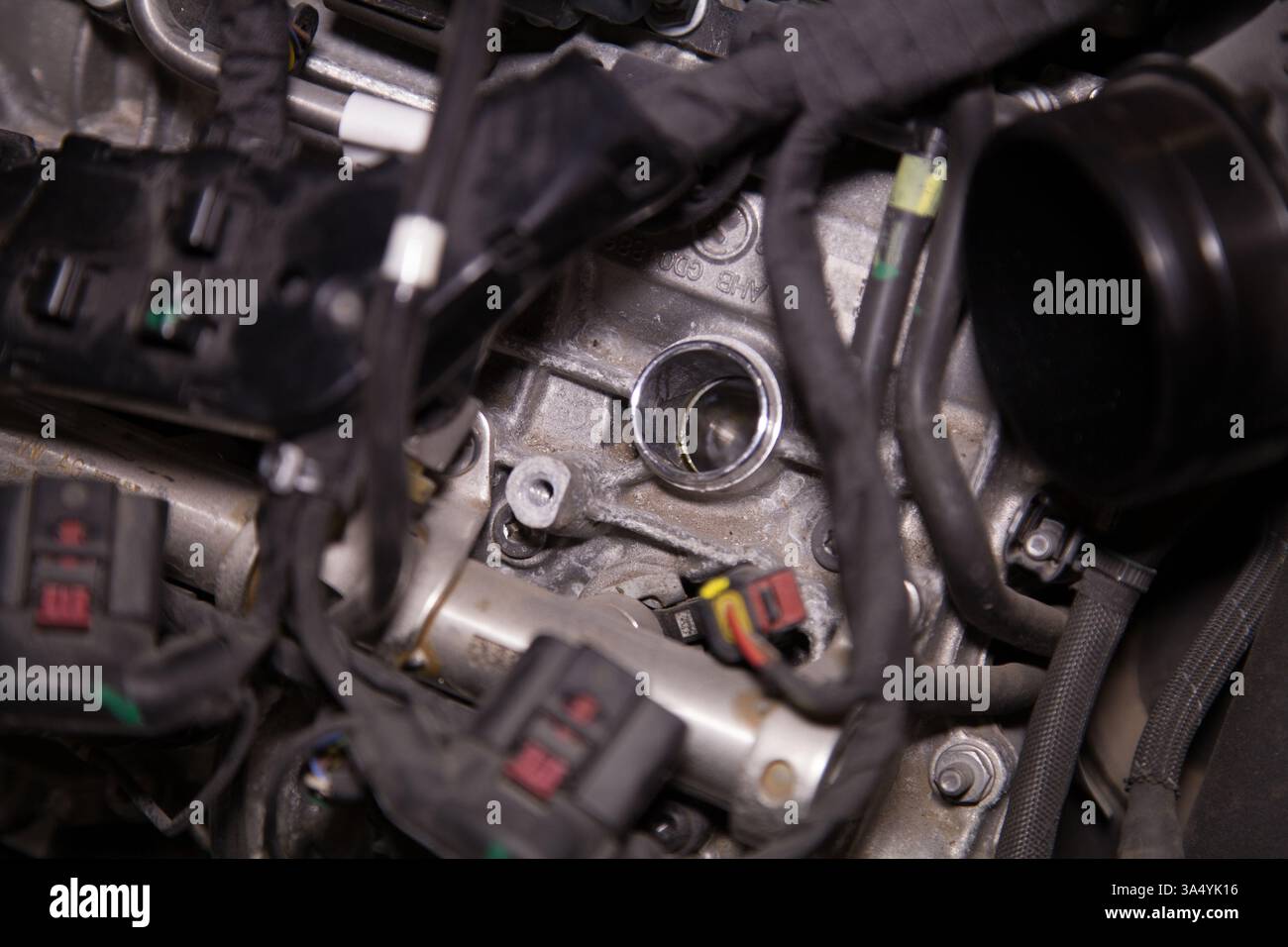 A partially disassembled engine bay of a car with the engine cover ...