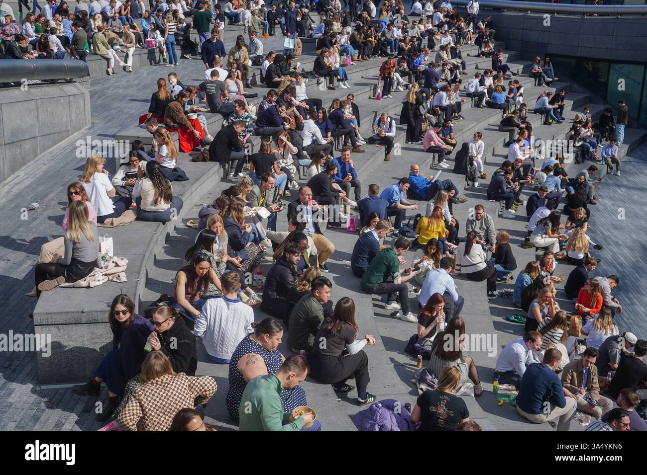 London, UK 20 March 2025. City workers enjoying their lunch break in ...