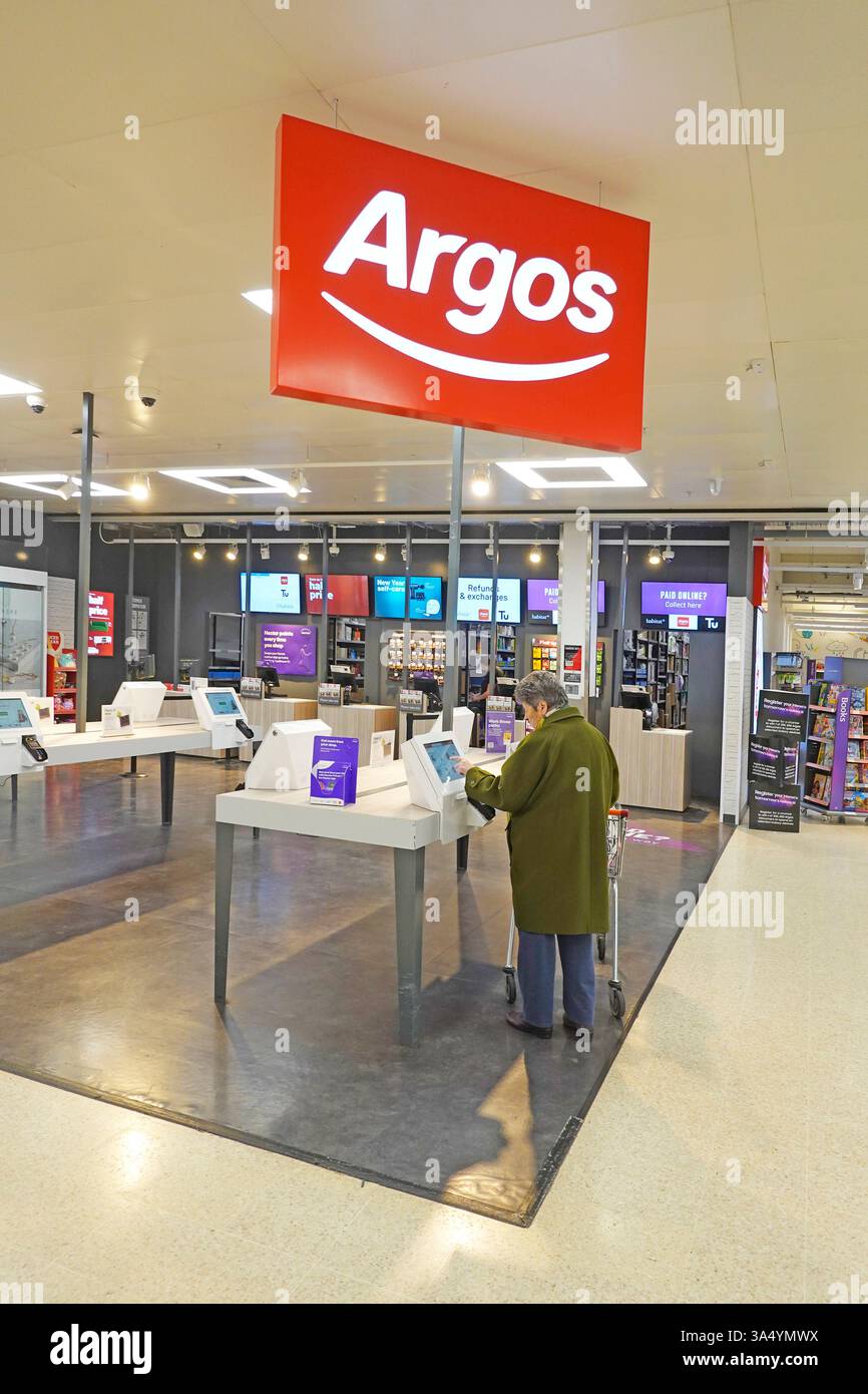 Back view model released woman customer shopping below large red Argos catalogue brand sign ...