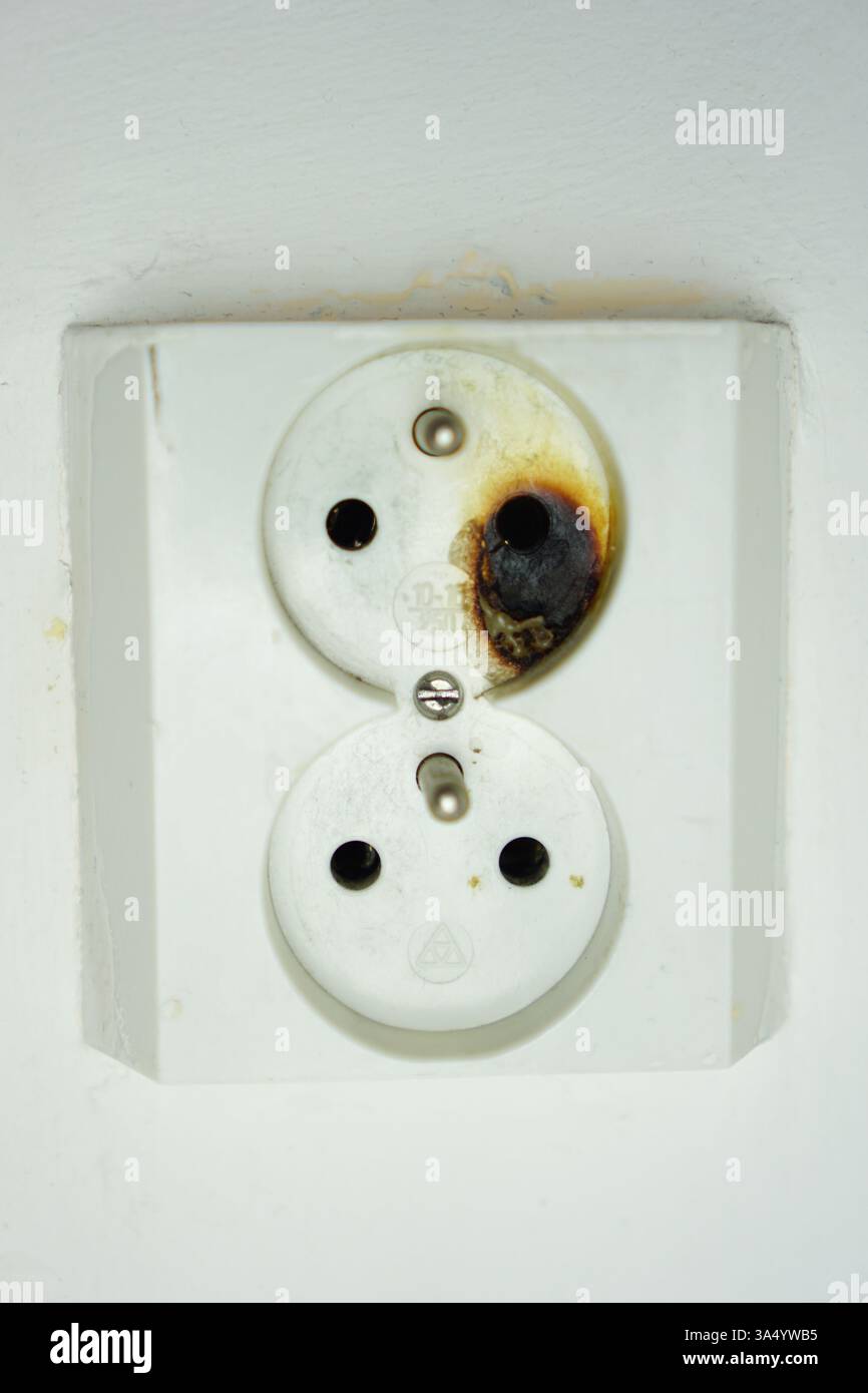 A melted and burnt electrical outlet, illustrating a significant fire ...