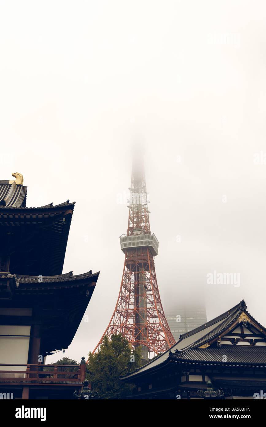 Mist covered Tokyo Tower rises above Zojo-ji temple where the soft ...