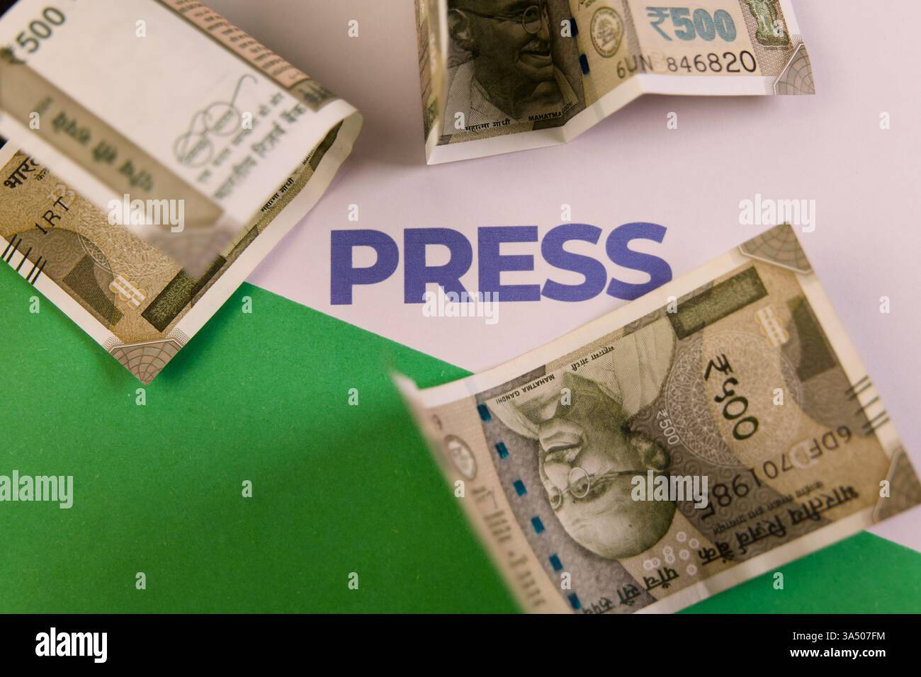 Currency notes are scattered on a colorful press card, showcasing an ...