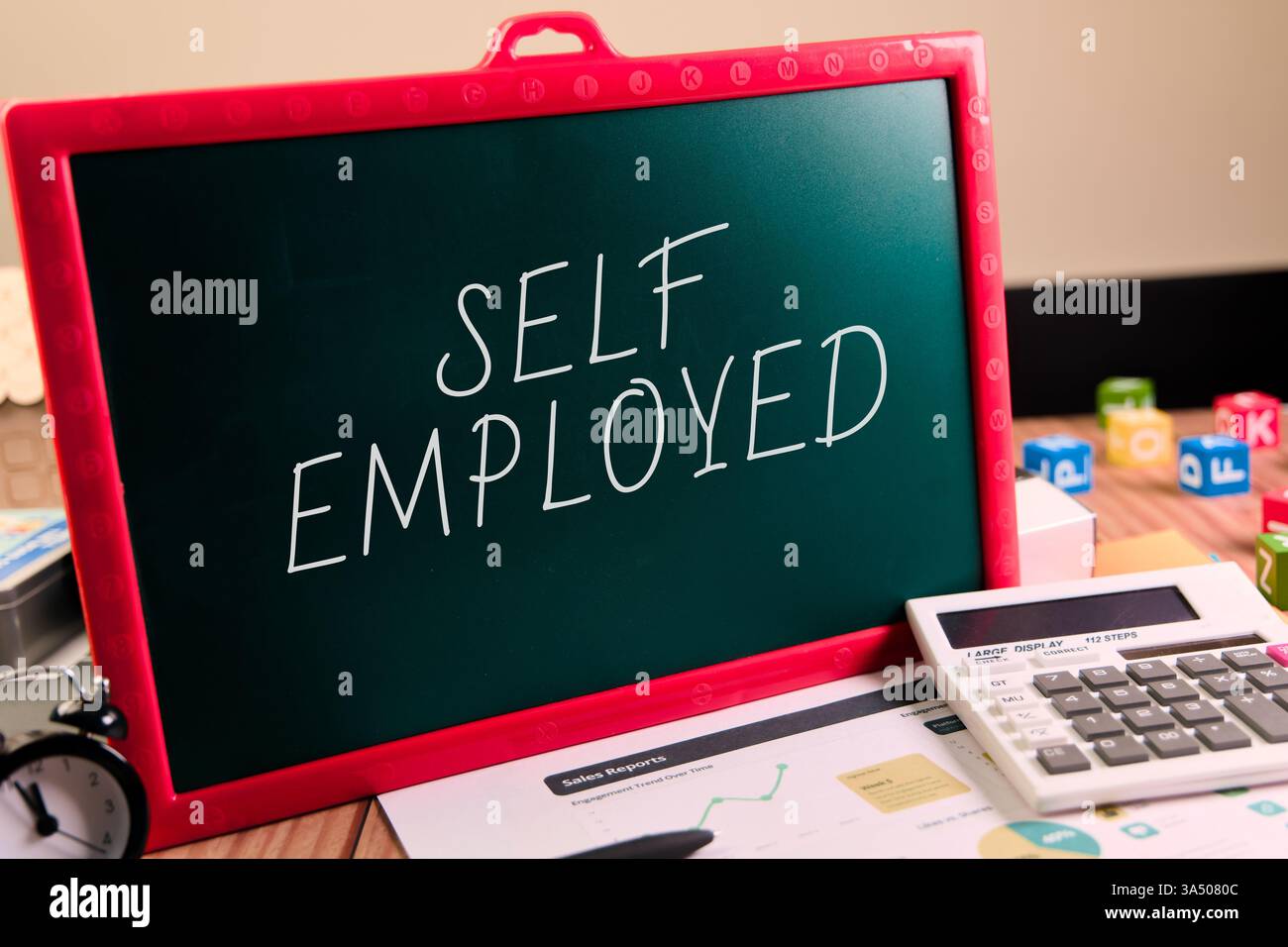 Chalkboard displays self employed while a calculator and reports ...