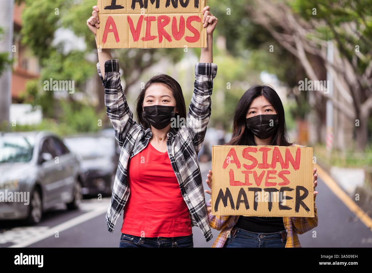 Asian women holding placards at a Stop Asian Hate protest on a city ...