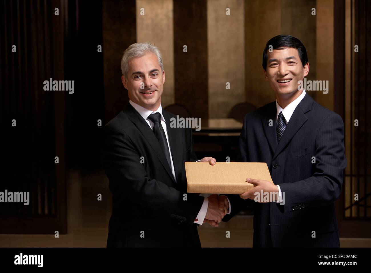 Two business leaders display a signed contract at an exclusive business ...
