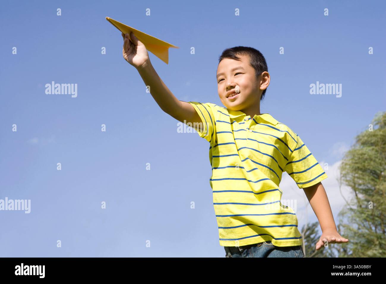 Chinese boy playing with a paper airplane Stock Photo - Alamy