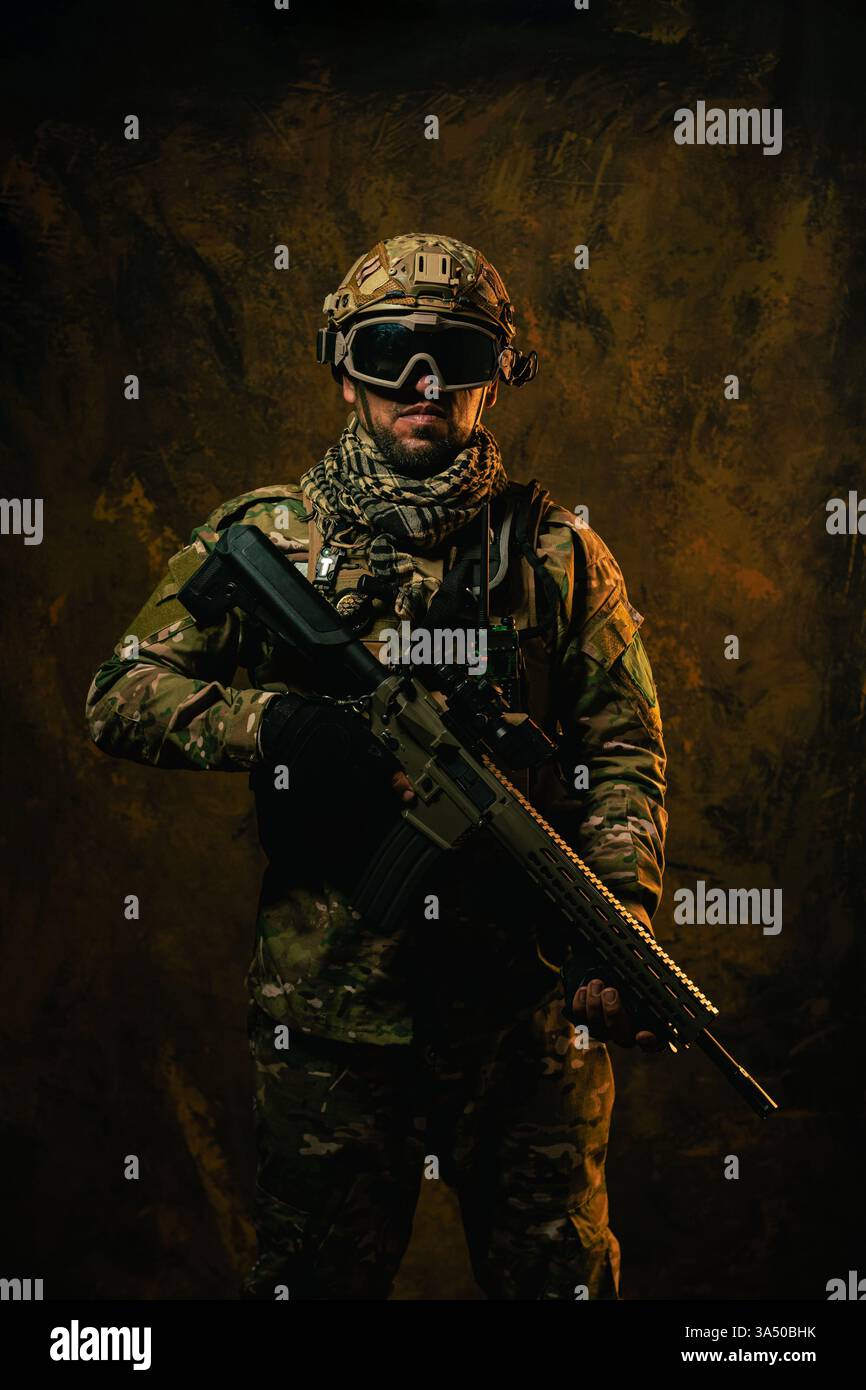 A highly equipped Latin American soldier stands alert, his rifle at the ...