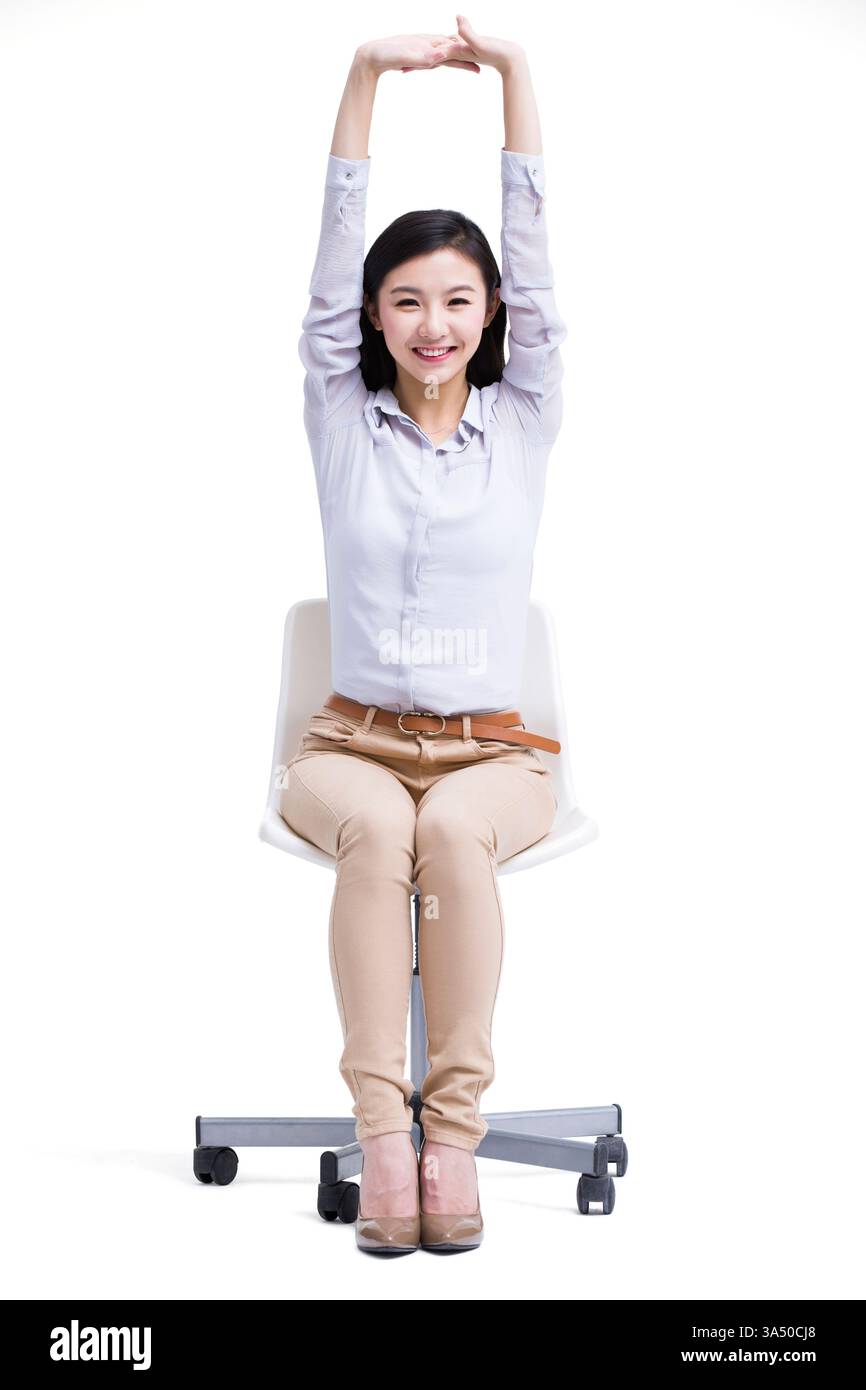 Young Chinese woman stretching in a bright studio. Casual wellness or ...