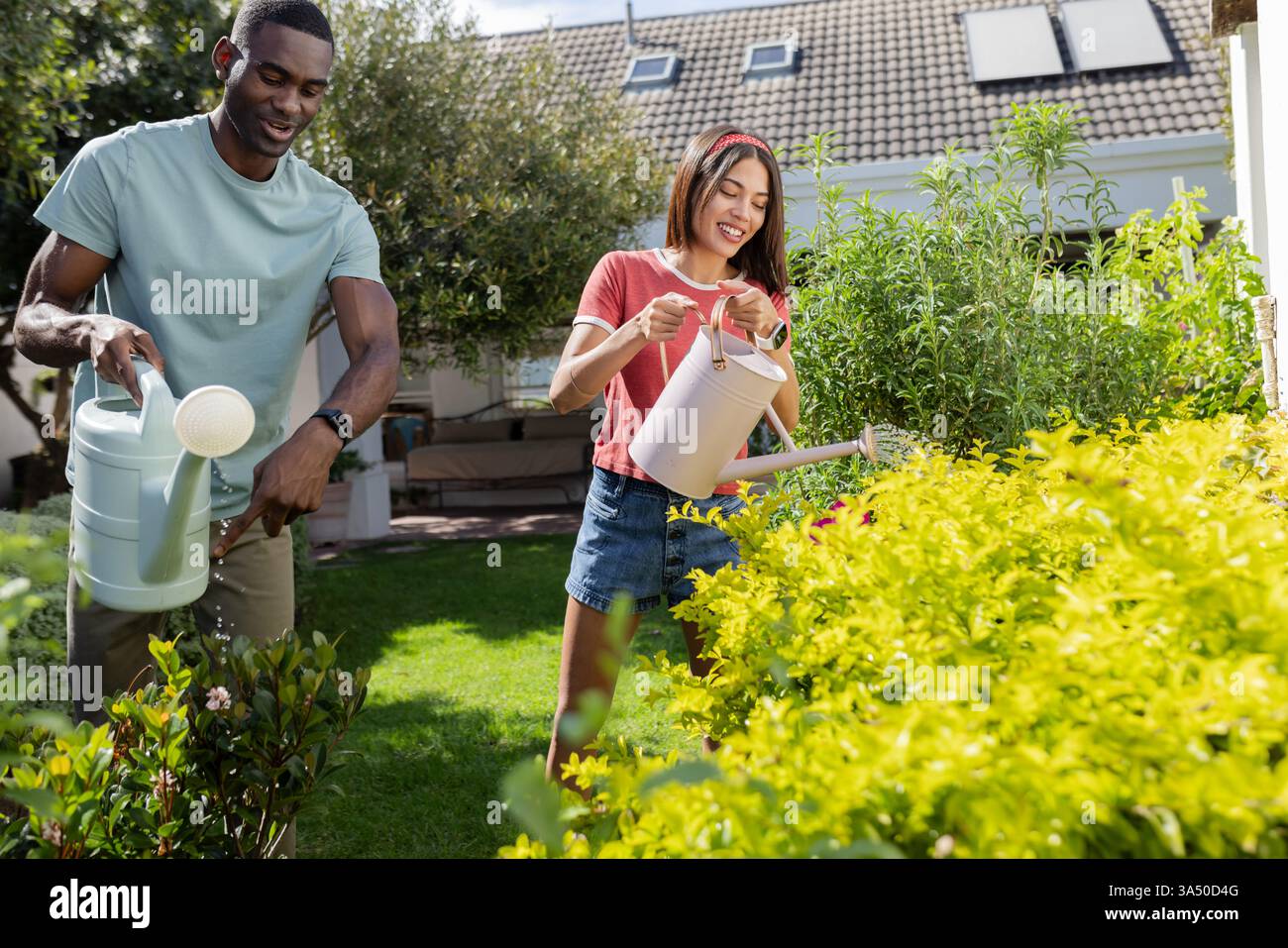 Smiling diverse couple watering hi-res stock photography and images - Alamy