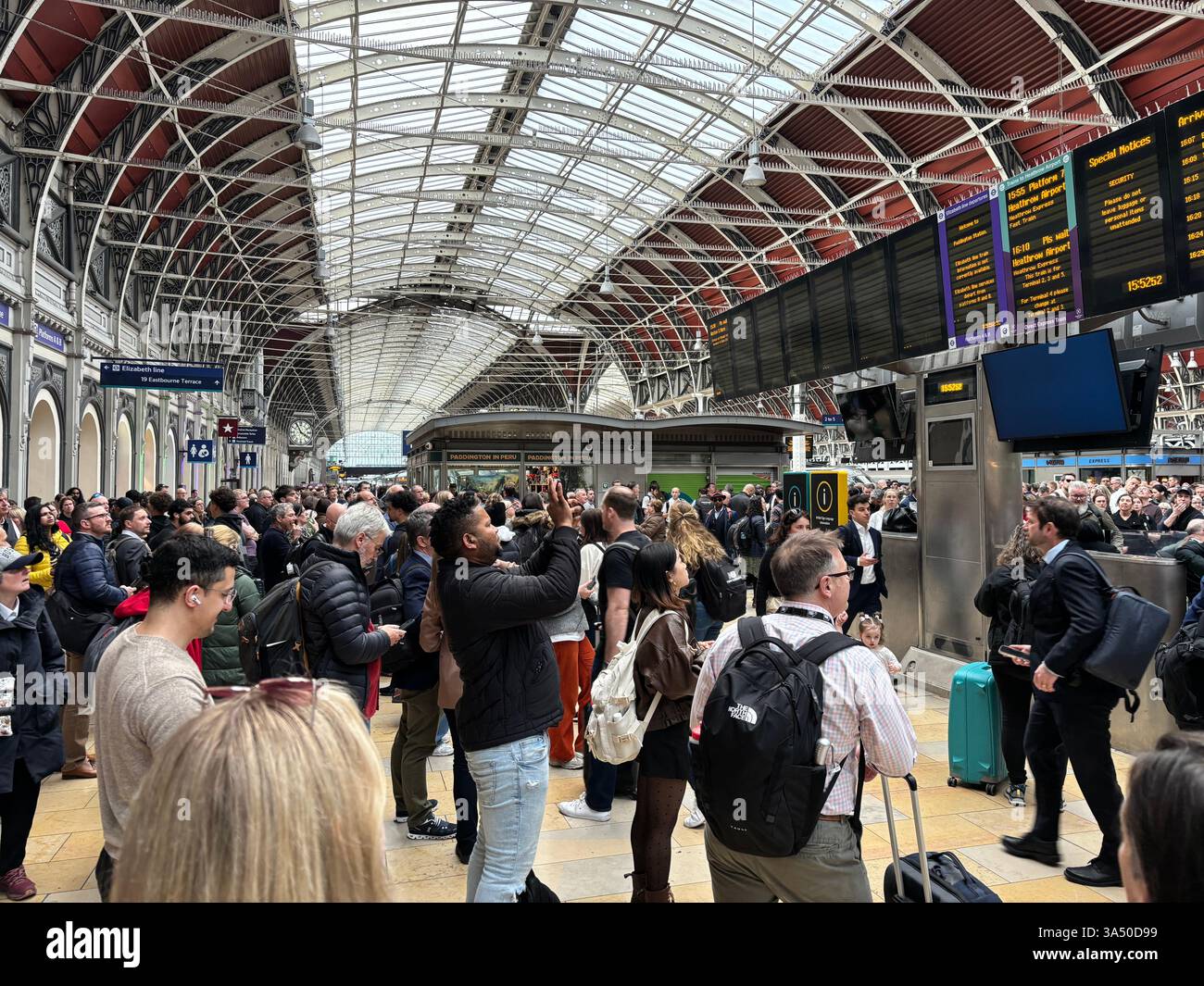 Passengers queue for trains at Paddington Station in London. Picture ...