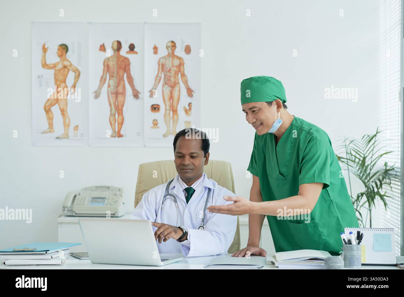 Positive doctors discussing medical history of patient on screen of ...
