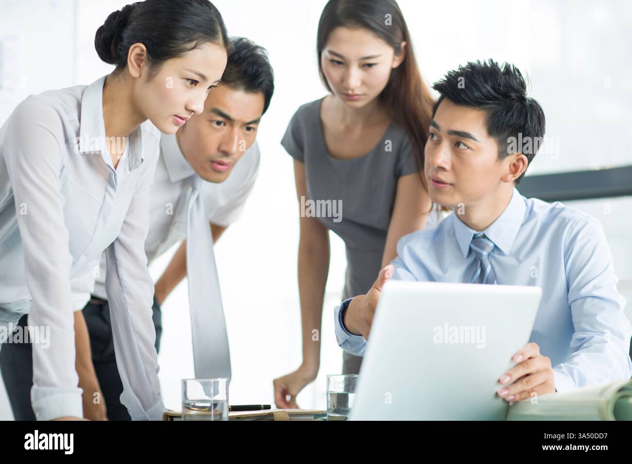 Chinese business people work together on a laptop in an office. Great ...